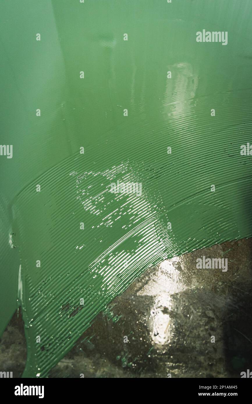 Floor under renovation with green epoxy resin.Applied over polished and ...