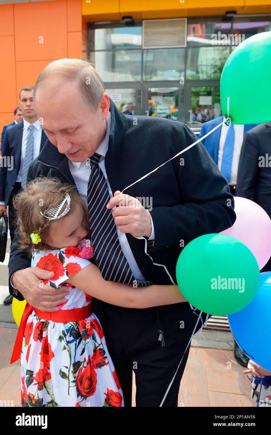 Russian President Vladimir Putin gets a hug from an unidentified girl, during a visit to the ...