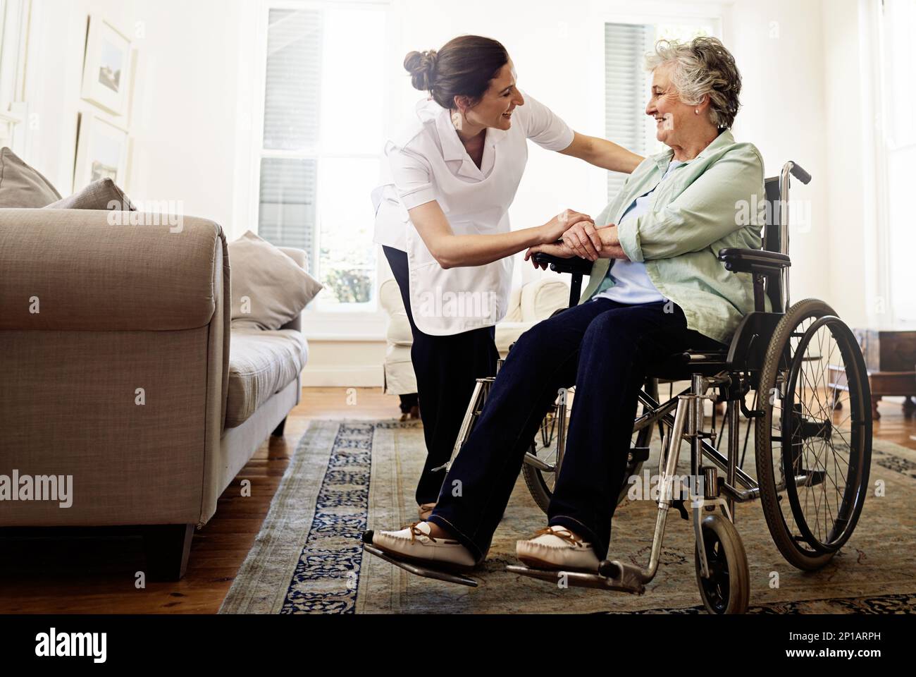 The best care you could hope for. Shot of a smiling caregiver helping a ...