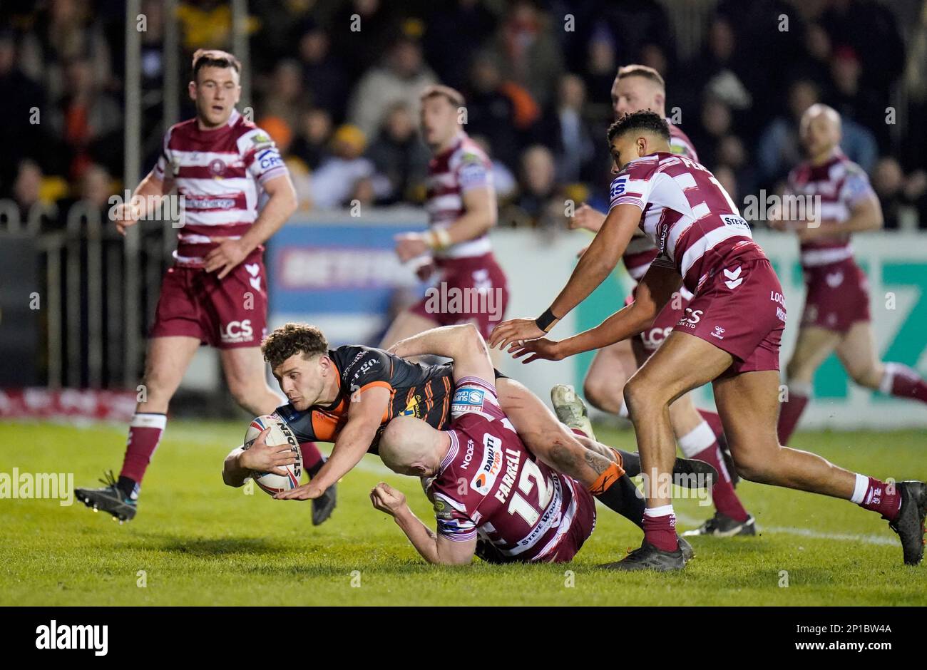 Castleford Tigers’ George Lawler is tackled by Wigan Warriors’ Liam ...