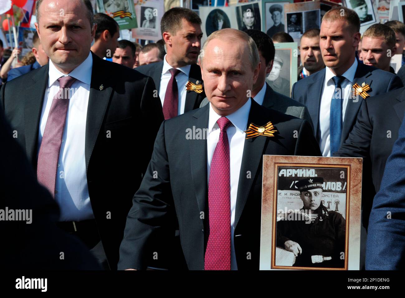 Russian President Vladimir Putin, center, holds a photograph of his ...