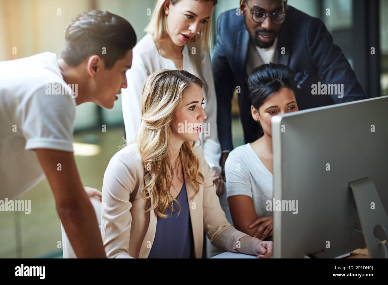 Tackling the problem as a team. Shot of a group of colleagues using a ...