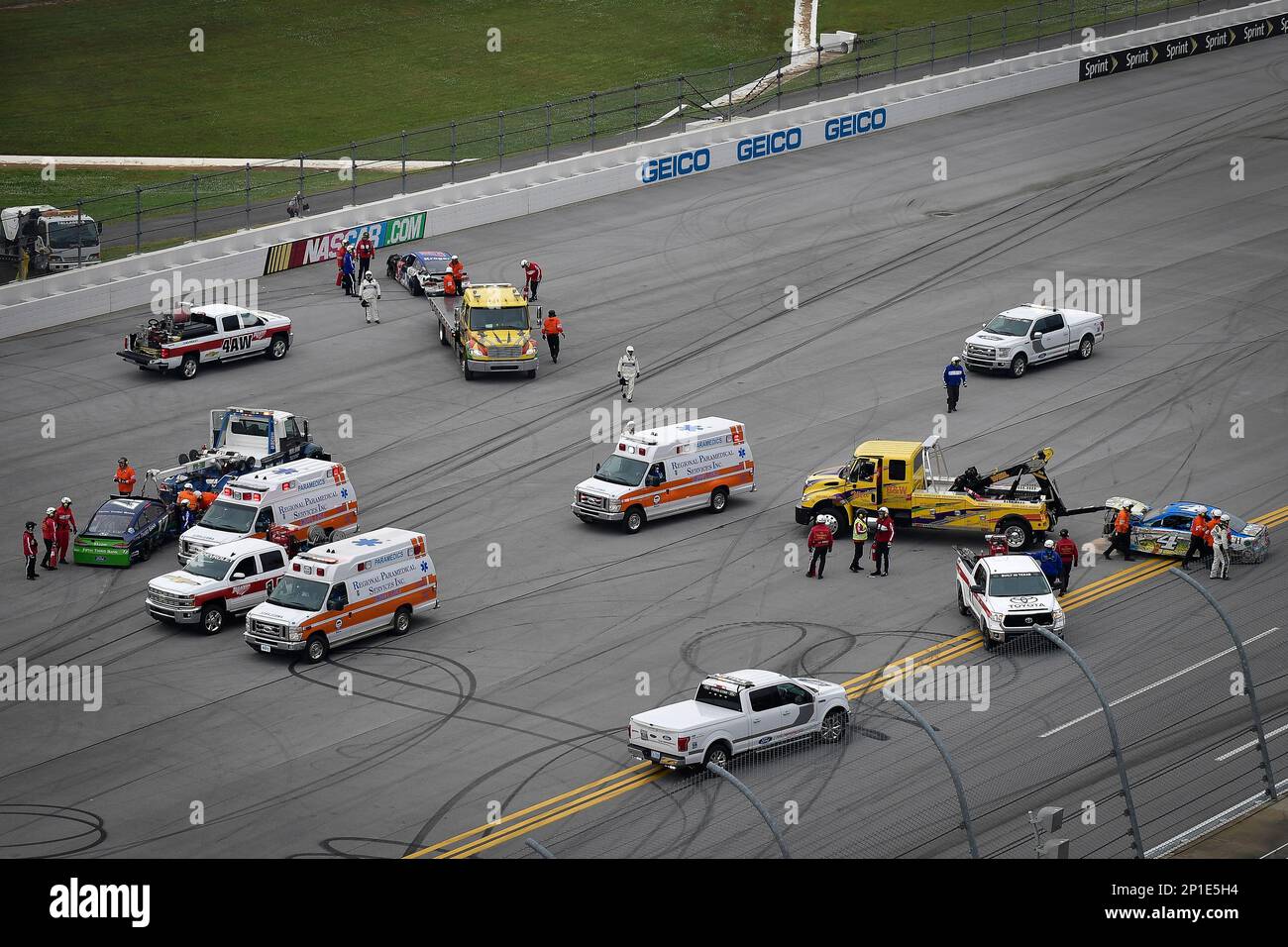 Emergency crews tend to the wreckage of a last lap crash during the ...