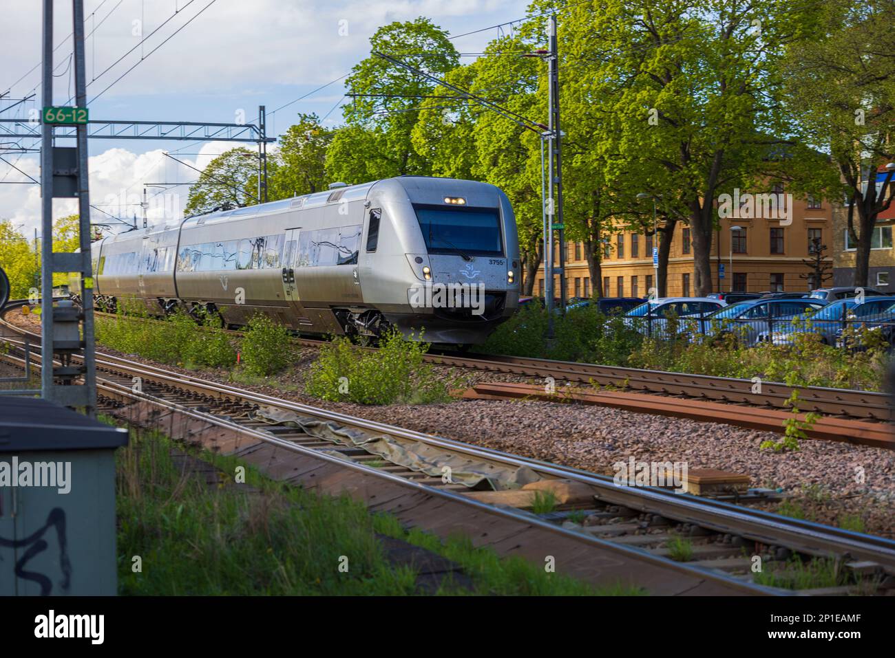View of coming speed electric train passing crossroad in town. Uppsala ...
