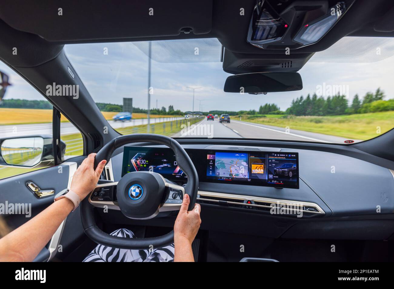 Woman driver driving BMW IX40 electric car on highway. Sweden Stock ...