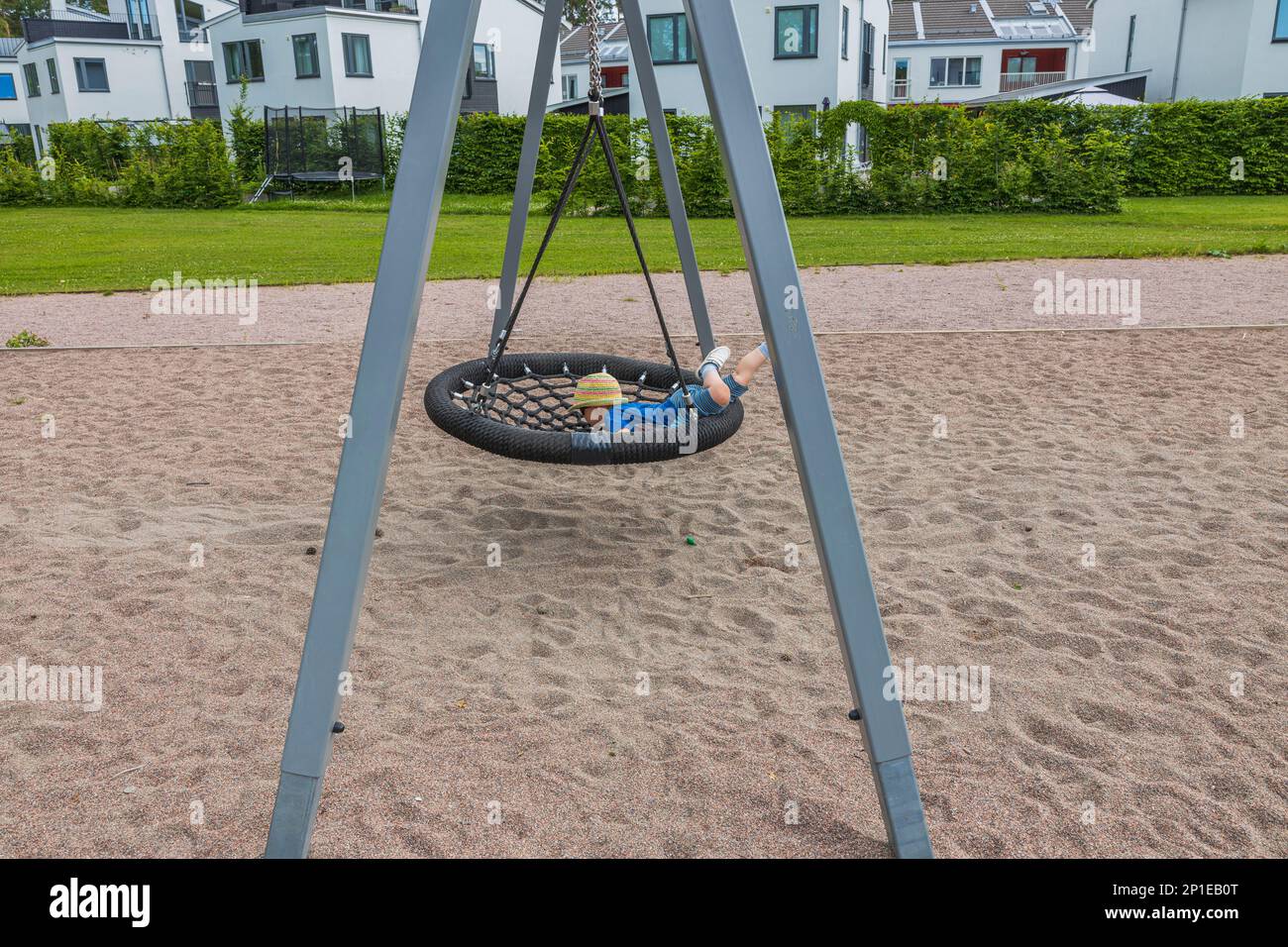 Beautiful view of child swinging on swing outdoors on playground in ...