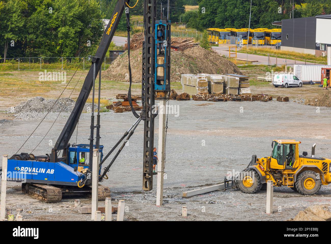 Pile driving machine driving piles into ground site on construction ...