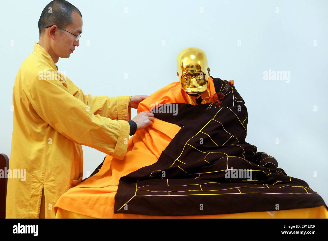 In this photo taken April 16, 2016, abbot Zhen Yu places a robe on the ...