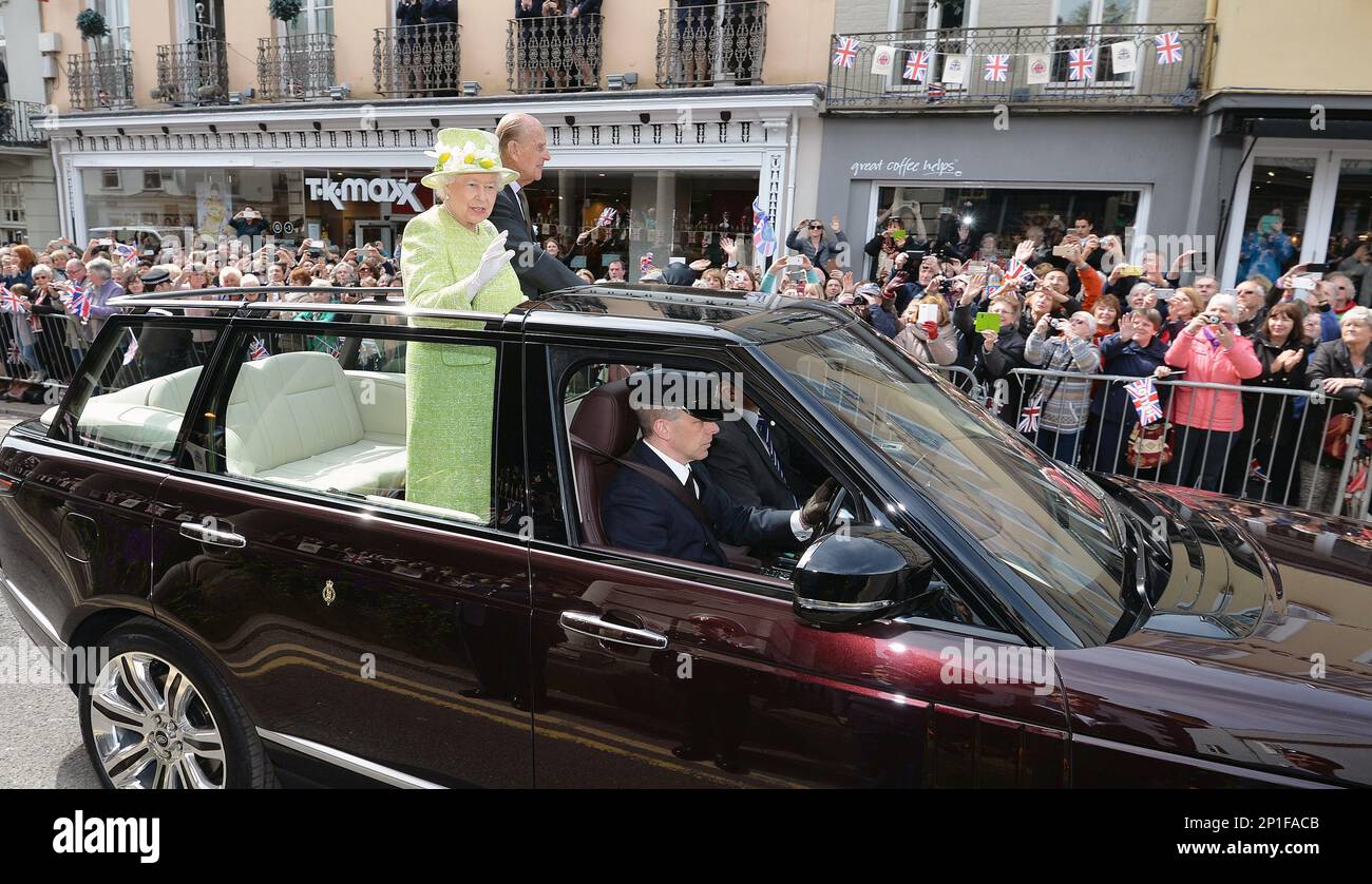 Britain's Queen Elizabeth II and Prince Philip ride in an open-topped ...