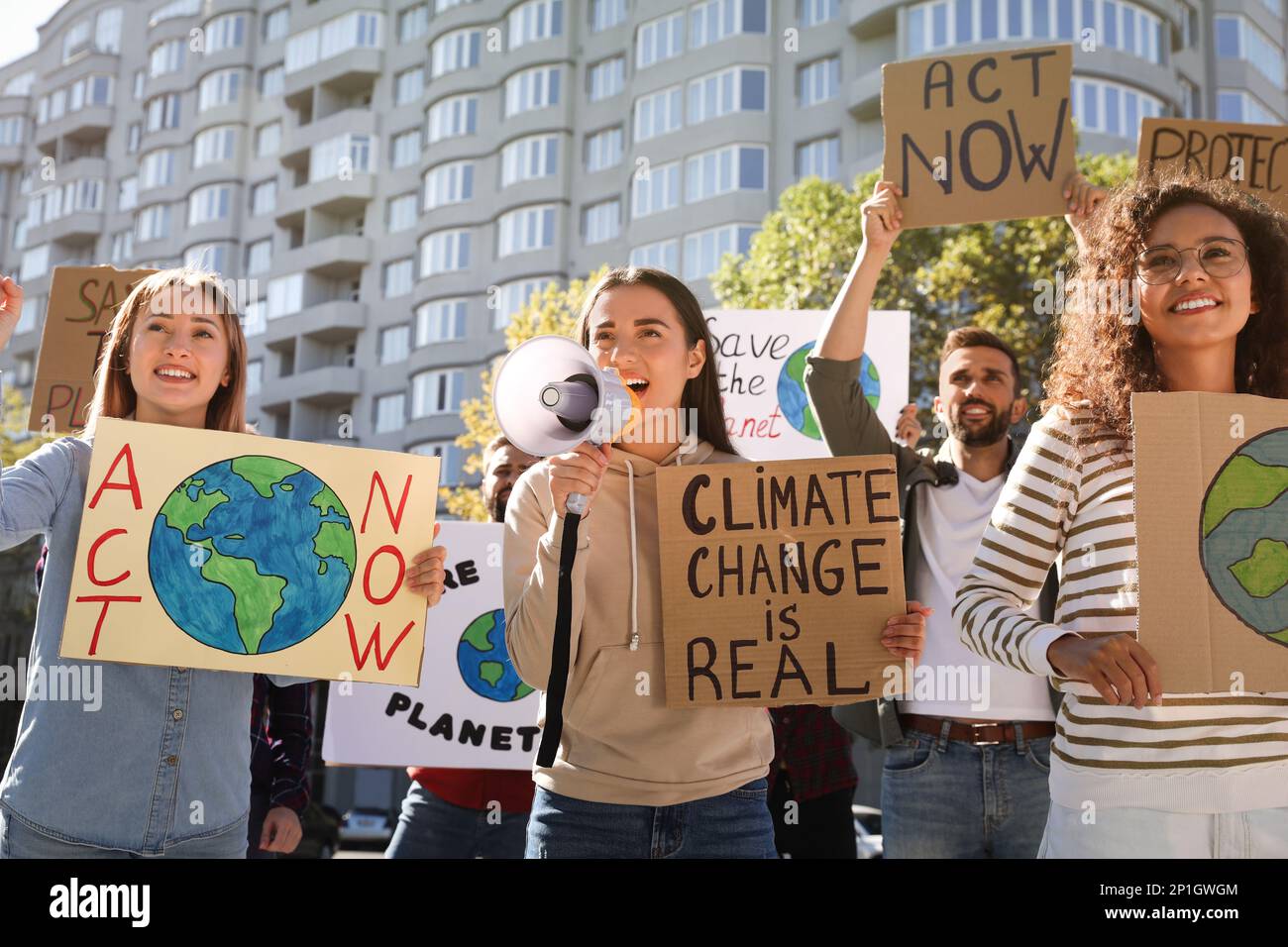 Group of people with posters protesting against climate change outdoors ...