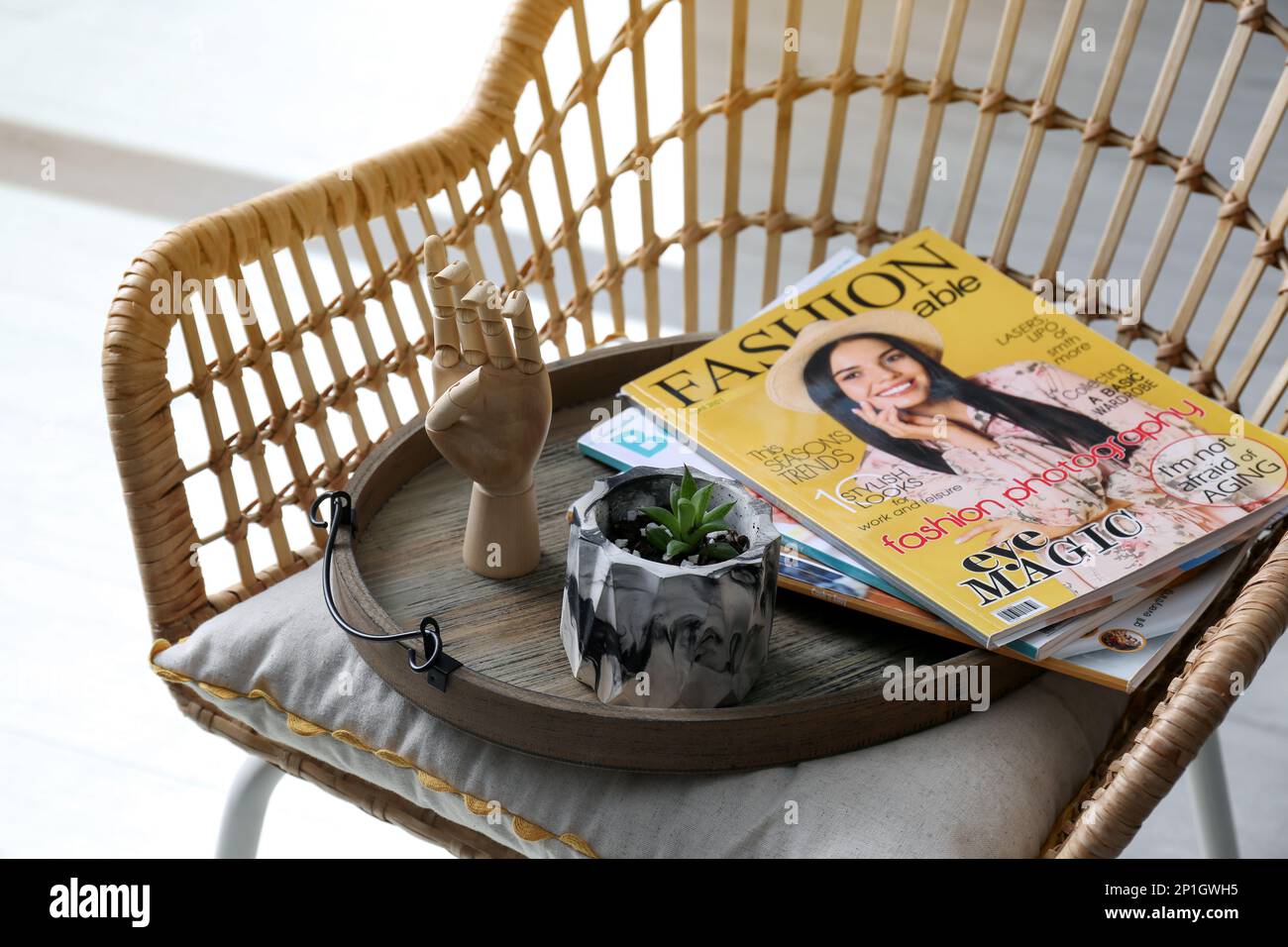 Wooden tray with houseplant and magazines on chair indoors Stock Photo ...