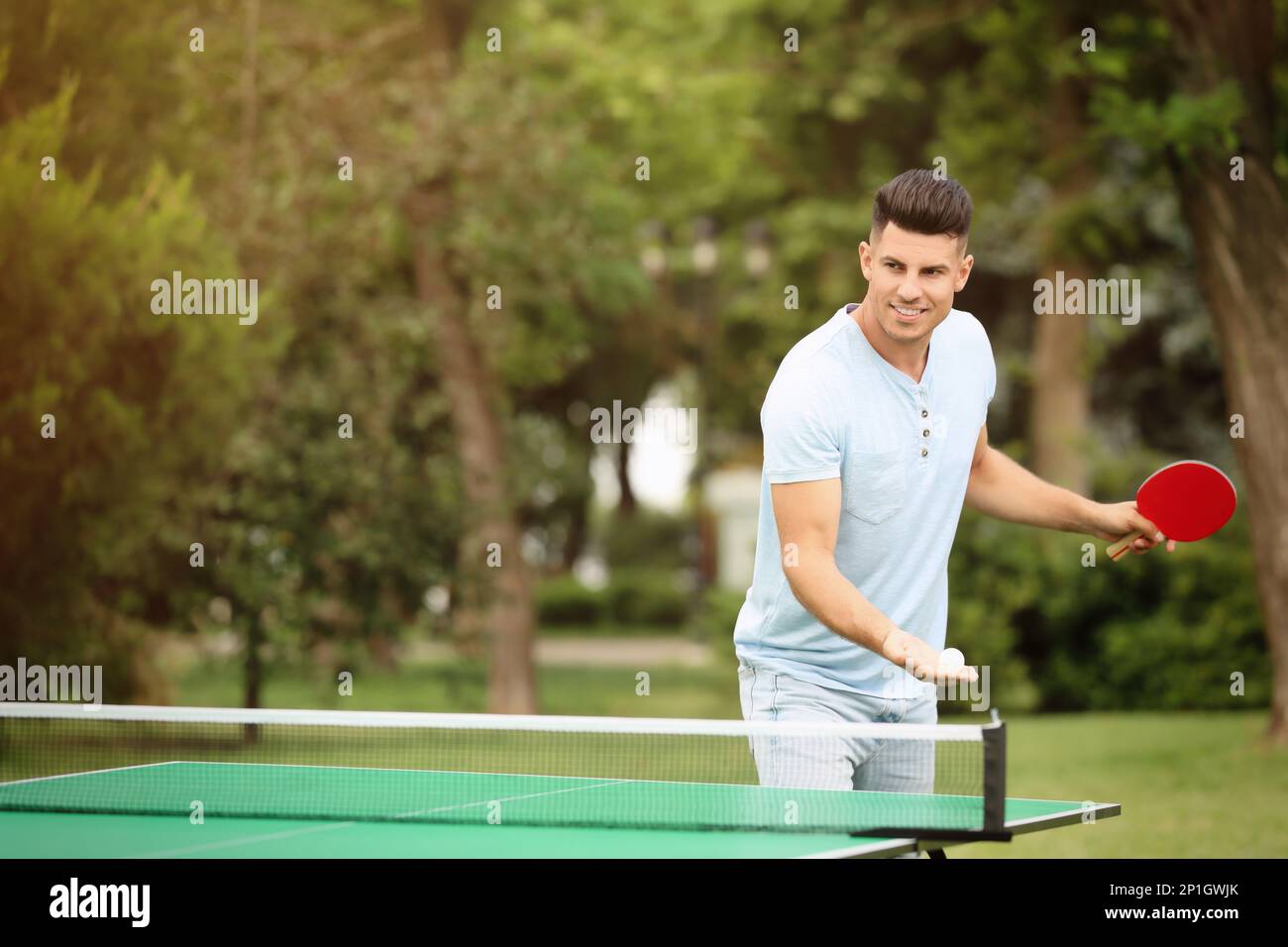 Happy man playing ping pong outdoors on summer day Stock Photo - Alamy