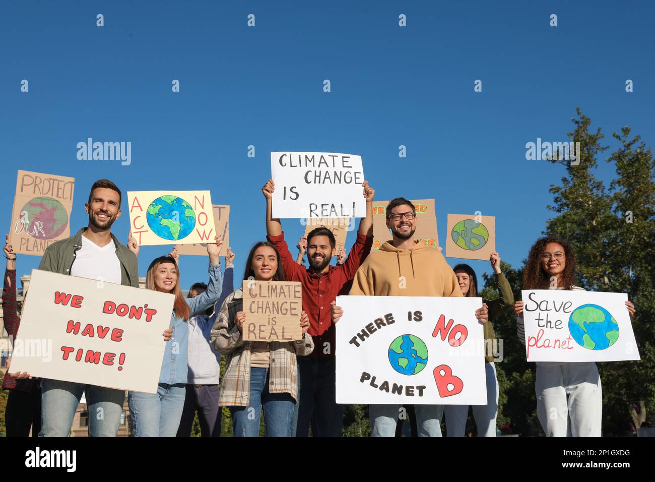 Group of people with posters protesting against climate change outdoors ...