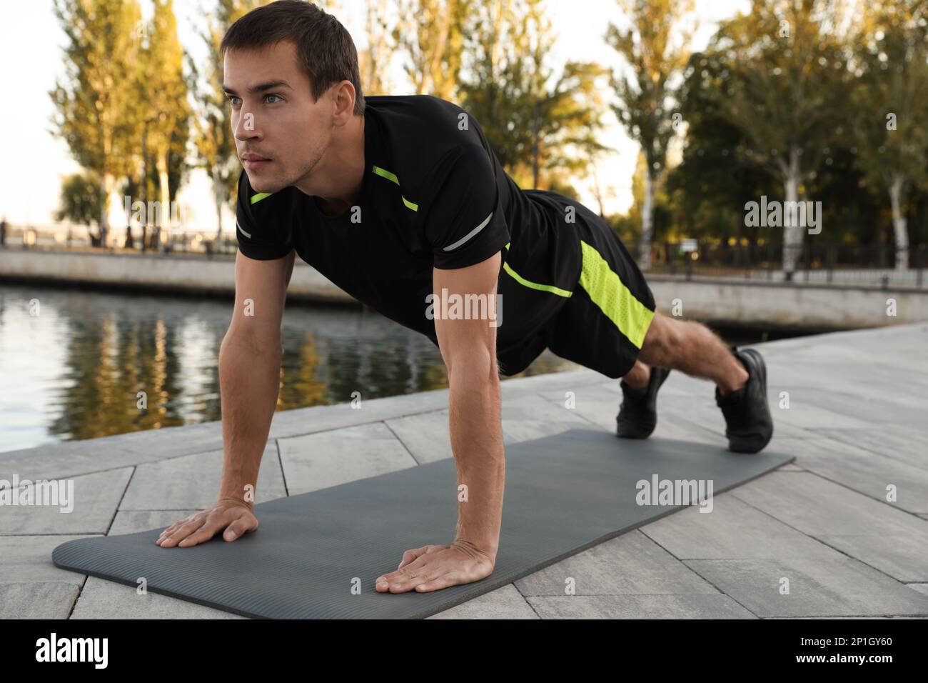 Sporty man doing straight arm plank exercise near river Stock Photo - Alamy