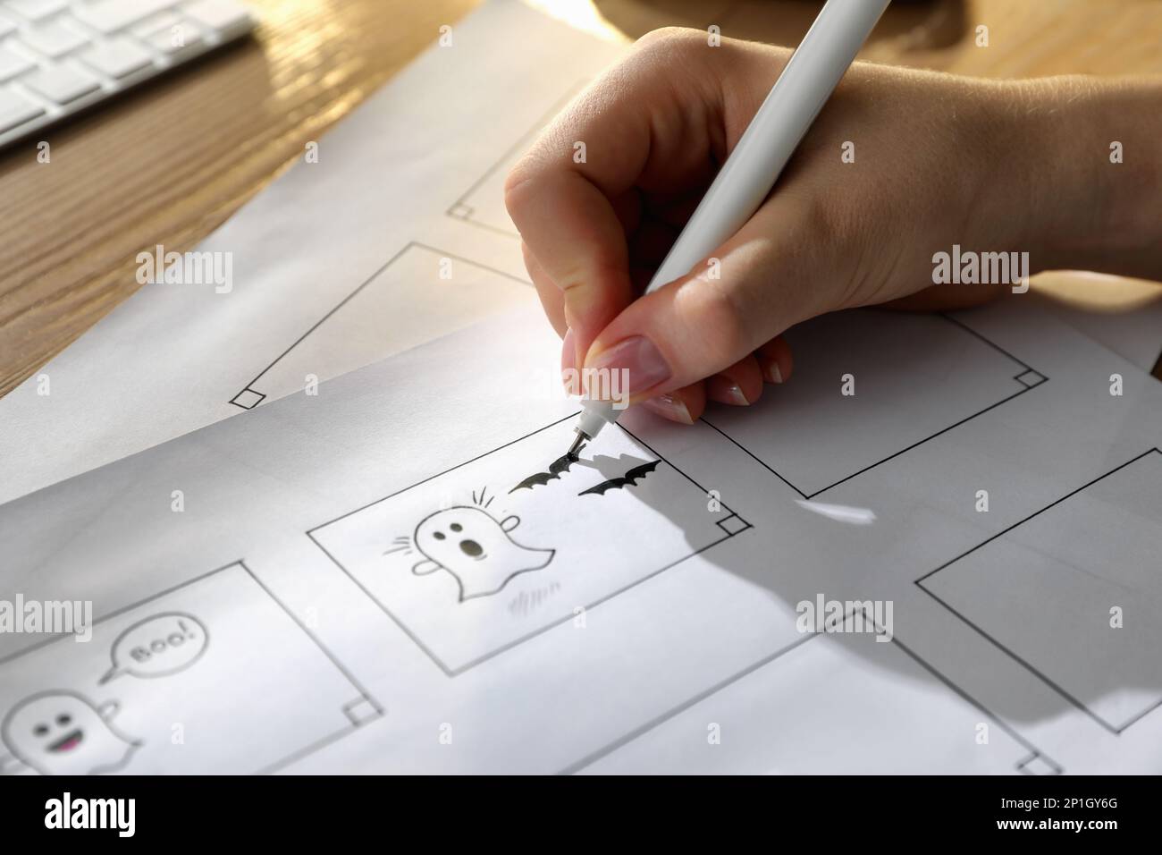 Woman drawing cartoon sketches at workplace, closeup. Pre-production ...