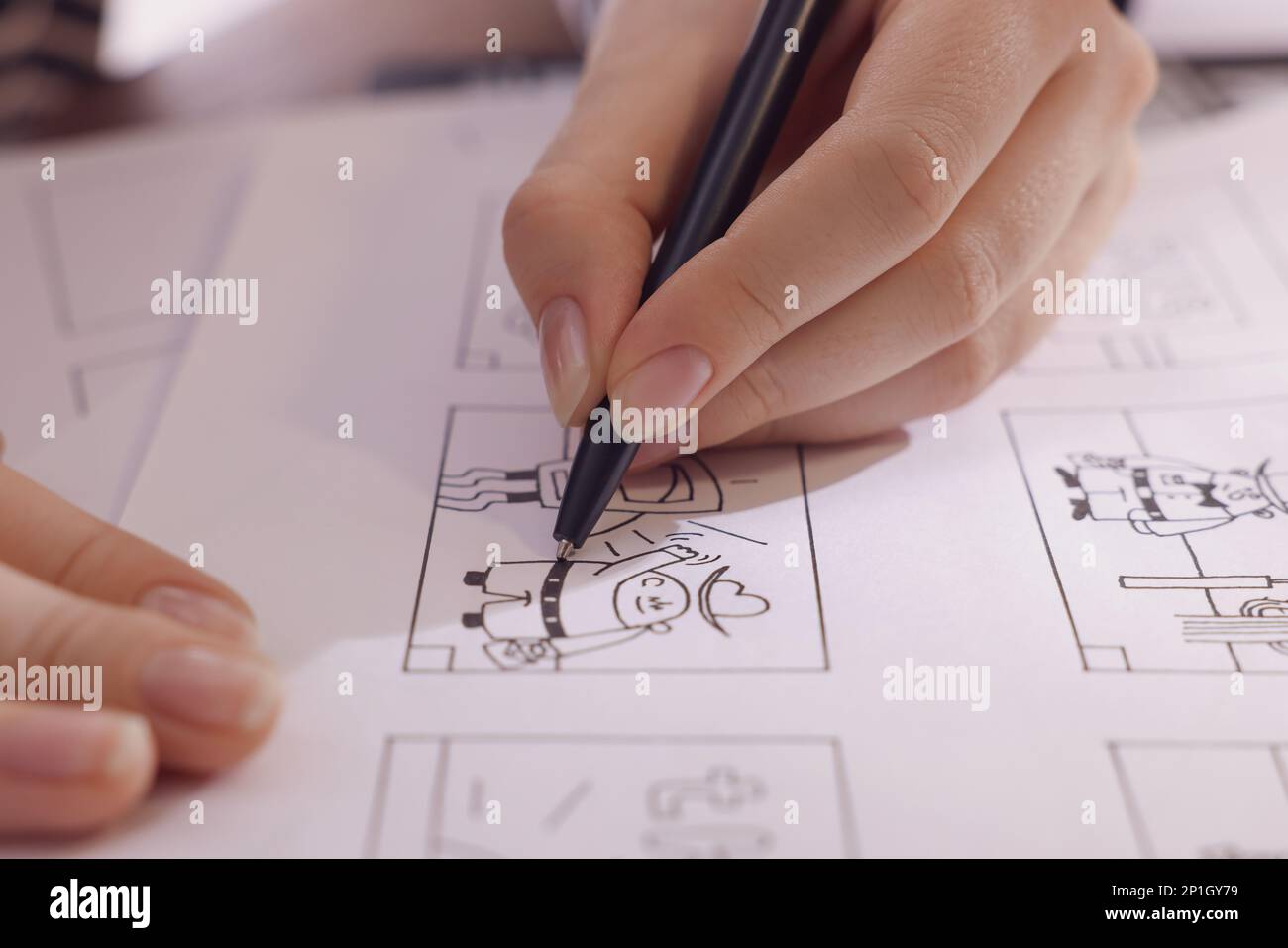 Woman drawing cartoon sketch at workplace, closeup. Pre-production ...