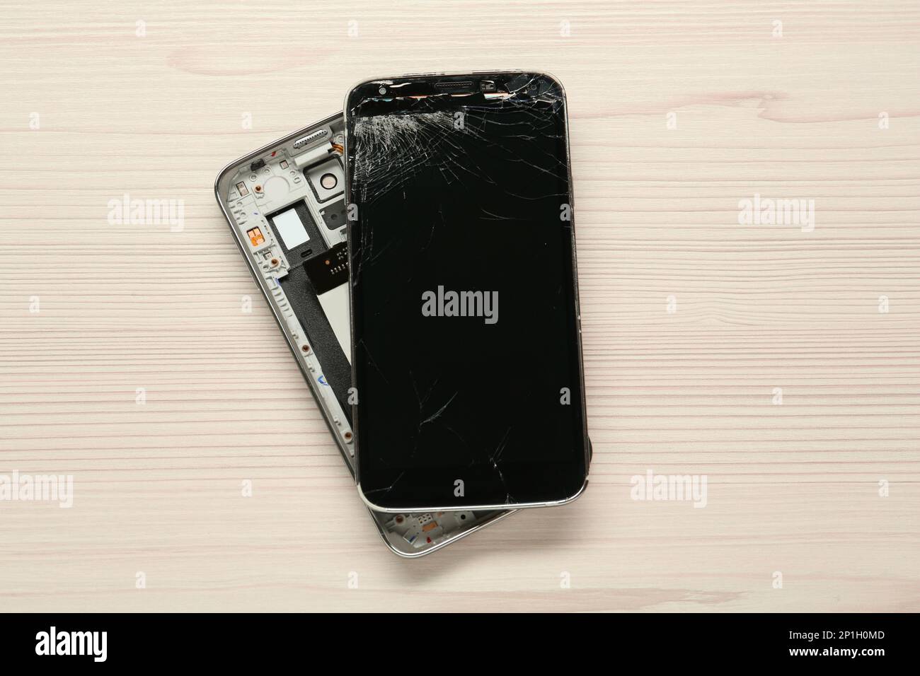 Damaged smartphone on wooden table, top view. Device repairing Stock ...