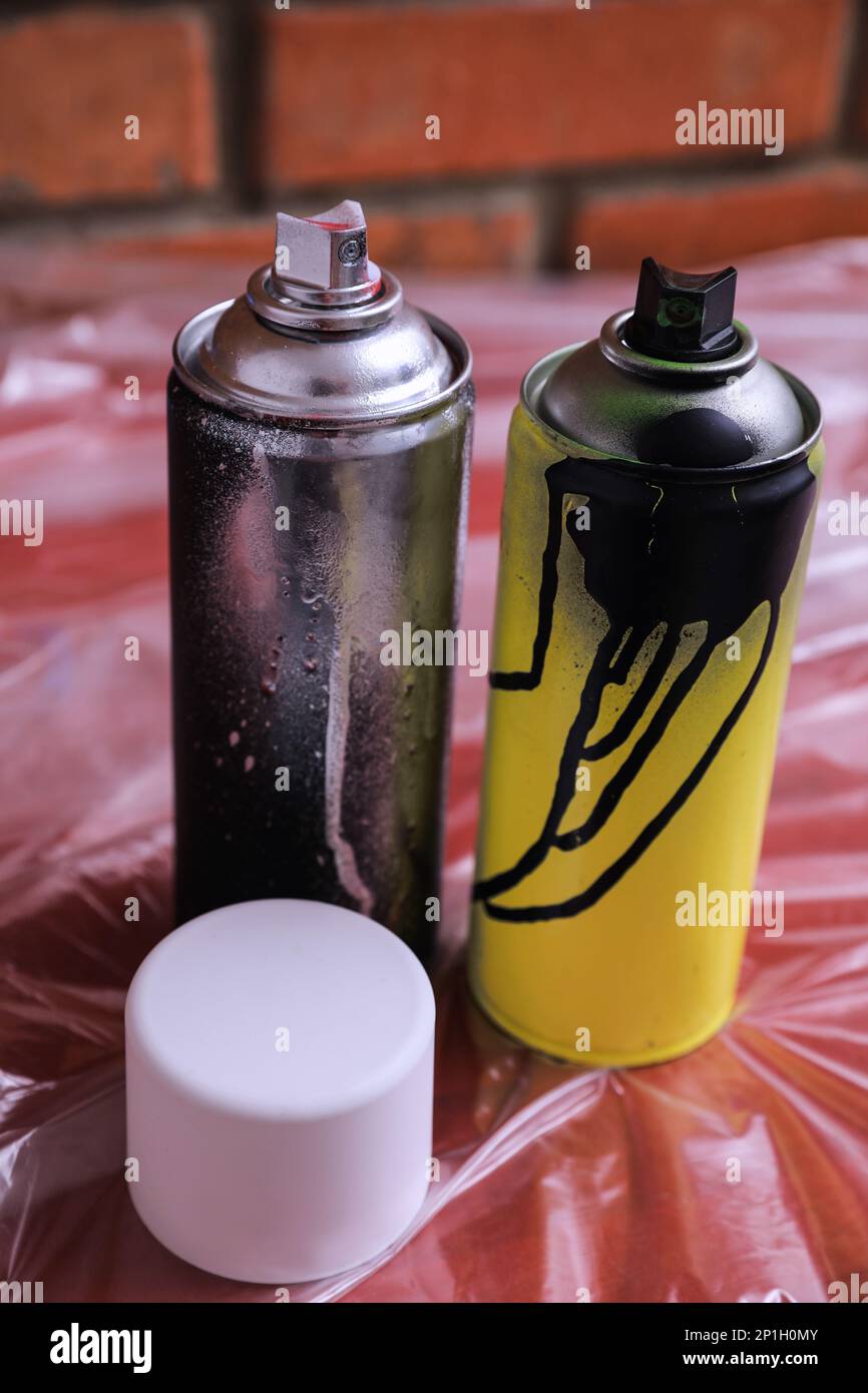 Used cans of spray paints on table. Graffiti supplies Stock Photo - Alamy