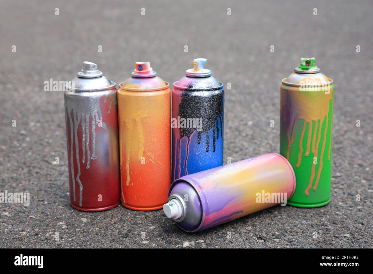 Used cans of spray paint on asphalt road. Graffiti supplies Stock Photo ...