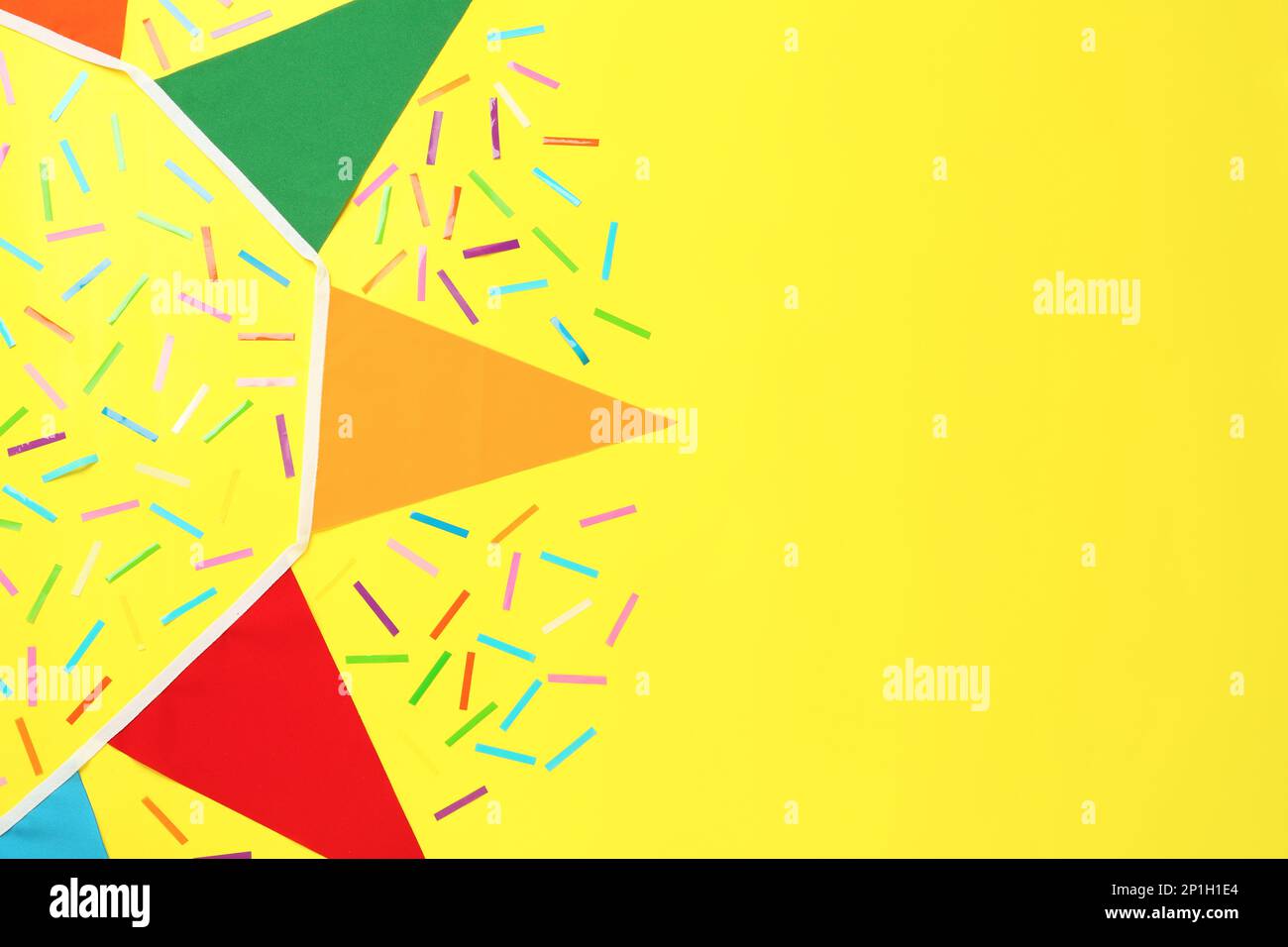 Bunting with colorful triangular flags and confetti on yellow ...