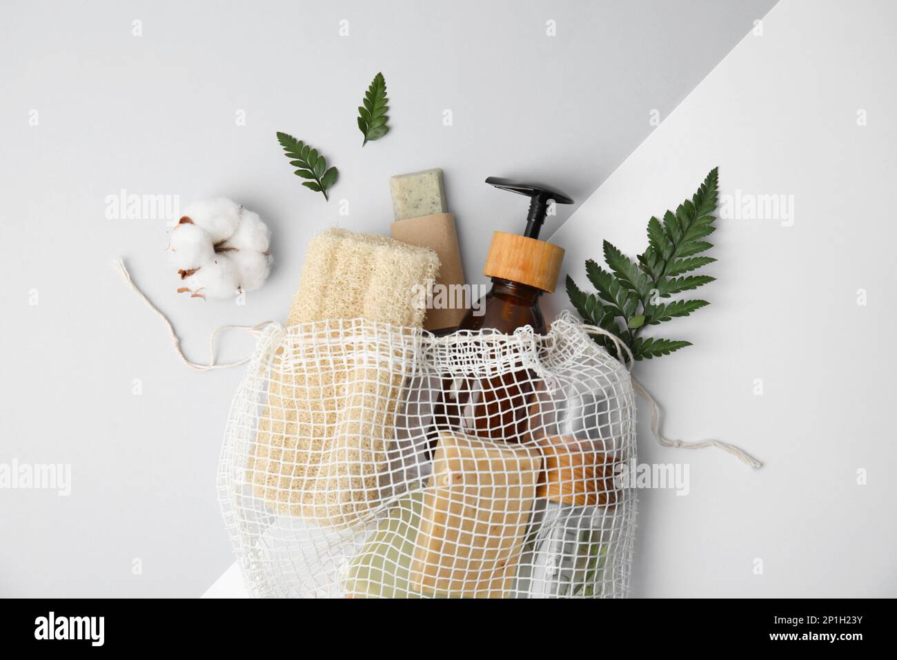 Mesh bag with eco friendly personal care products on color background ...