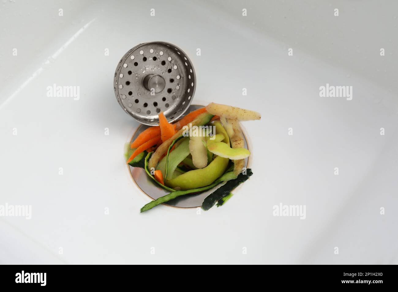 Vegetable scraps in kitchen sink with garbage disposal Stock Photo - Alamy