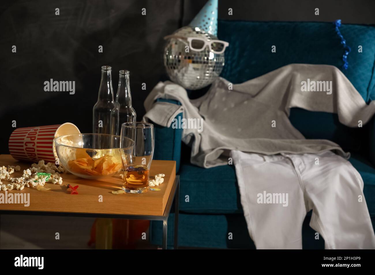 Messy table with food leftovers near clothes on armchair in room after ...