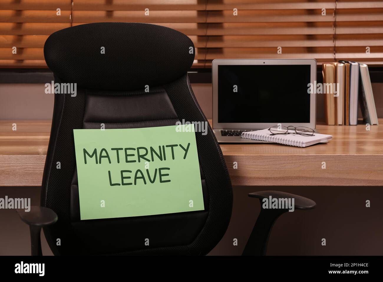 Note with text Maternity Leave on office chair back near workplace ...