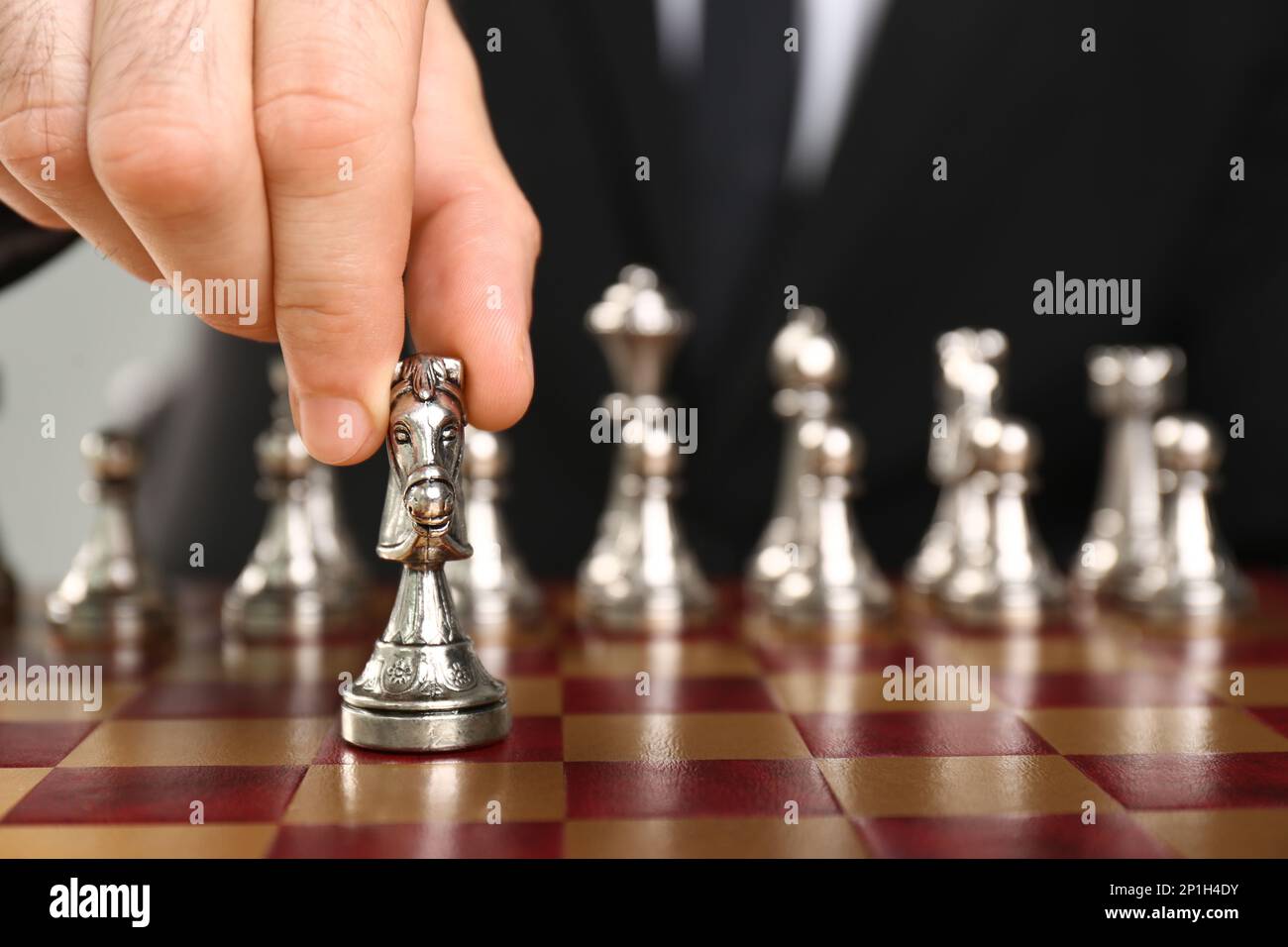 Man moving chess piece on board, closeup Stock Photo - Alamy