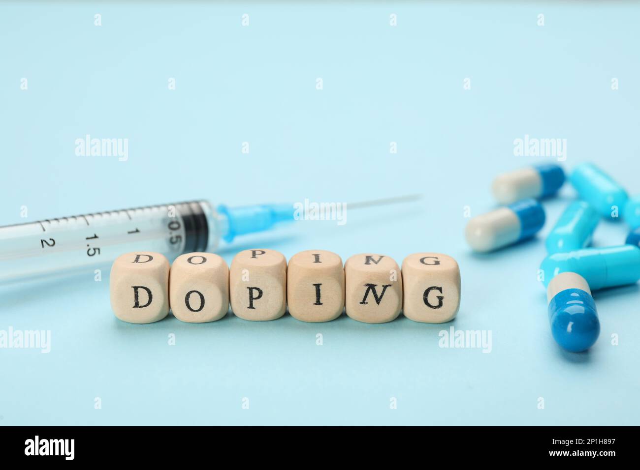 Wooden cubes with word Doping and drugs on turquoise background Stock ...