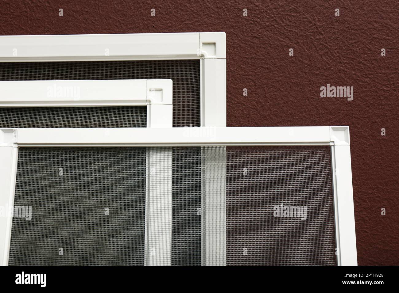 Set of window screens near brown wall, closeup Stock Photo - Alamy
