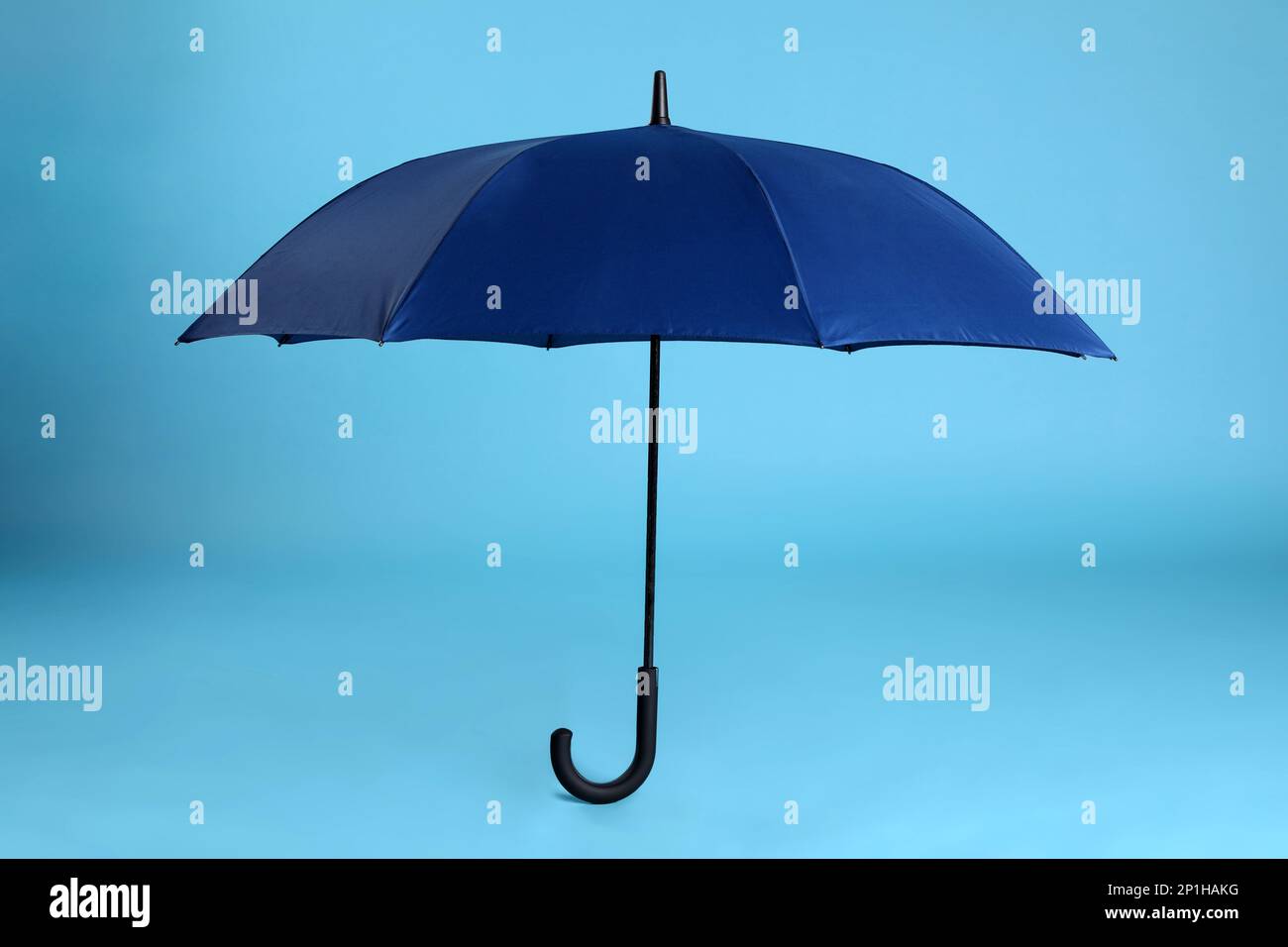 Stylish open bright umbrella on light blue background Stock Photo - Alamy