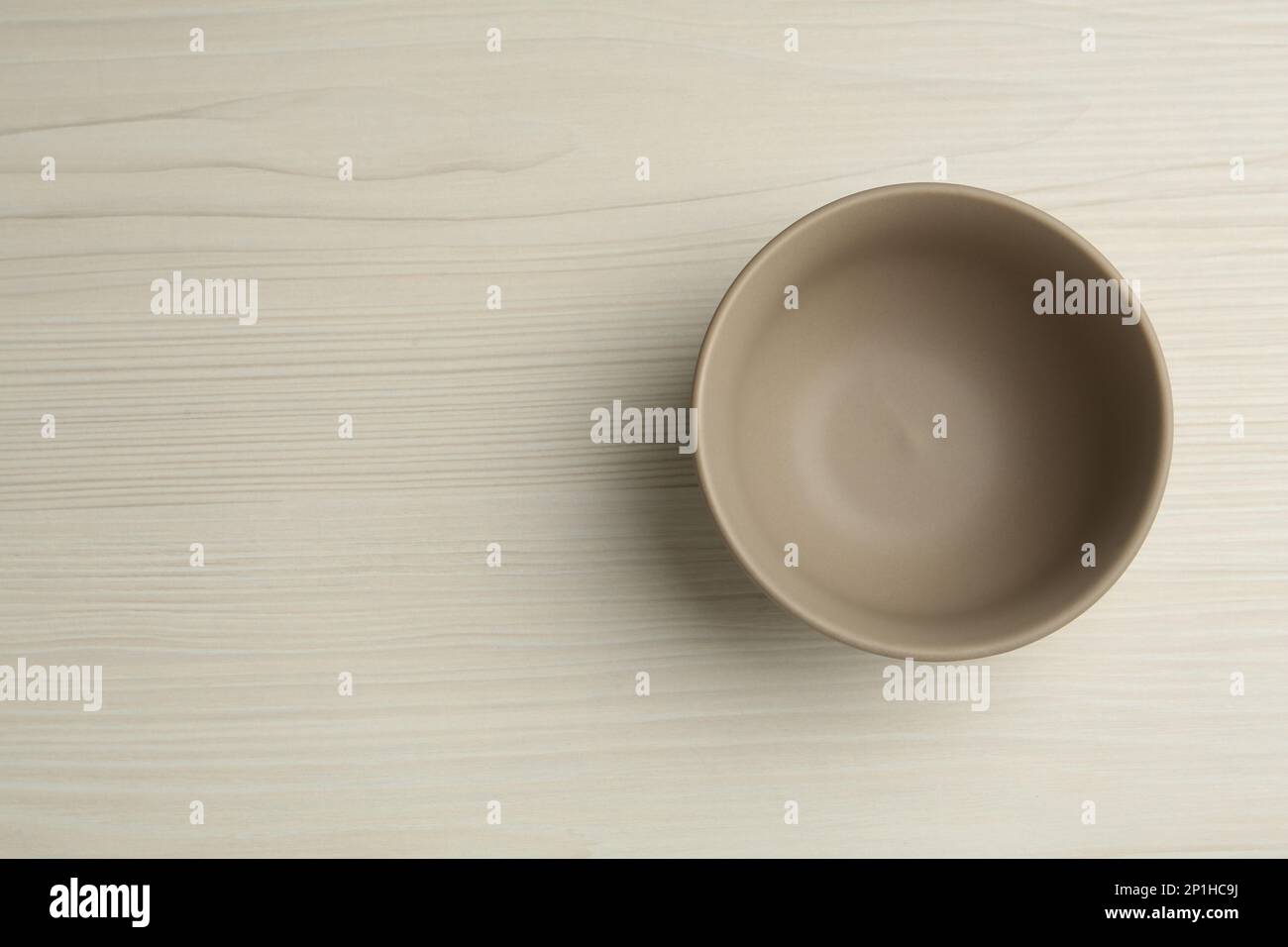 Stylish empty ceramic bowl on white wooden table, top view and space ...