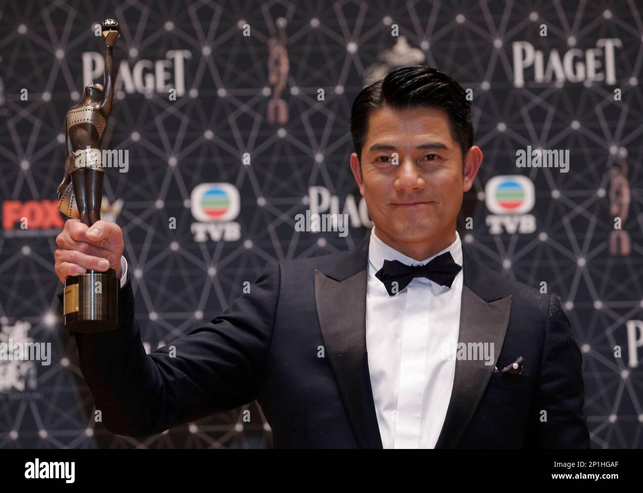 Hong Kong actor Aaron Kwok poses with a trophy after winning the Best ...
