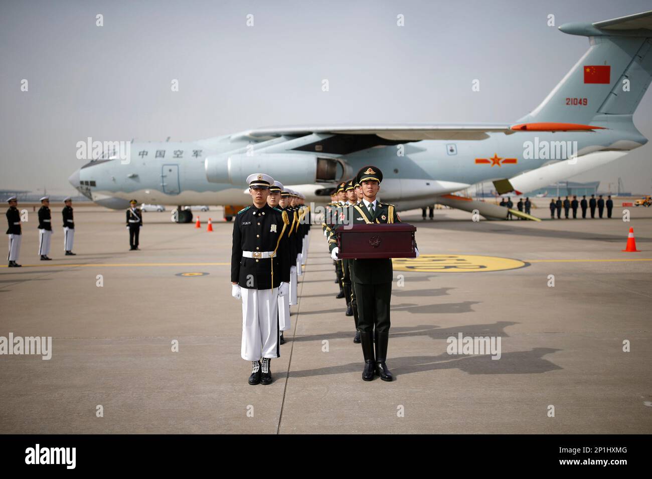 Members of a Chinese honor guard hold caskets containing the remains of ...