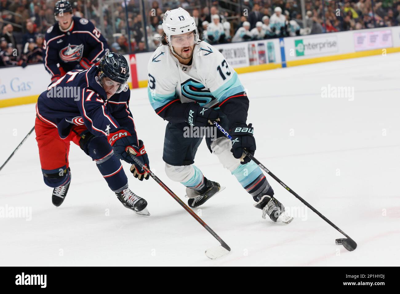 Seattle Kraken's Brandon Tanev, right, tries to shoot past Columbus ...