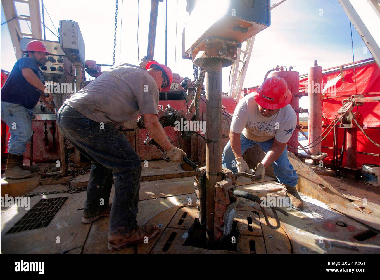 From left, Jerry Moore, driller, halts the drill pipe while Carl ...