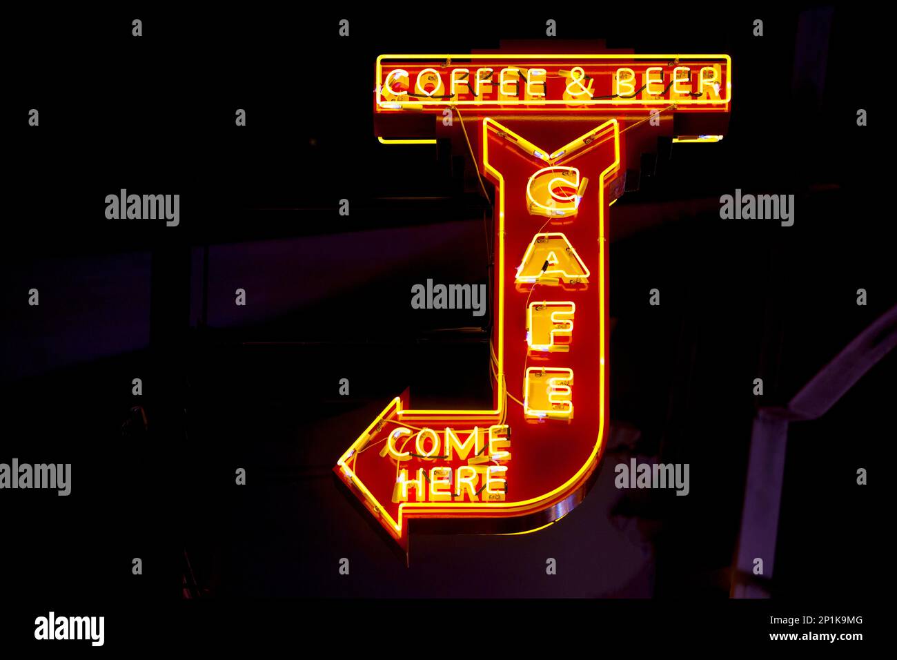 Neon light shaped into an arrow pointing left with the message "Coffee ...