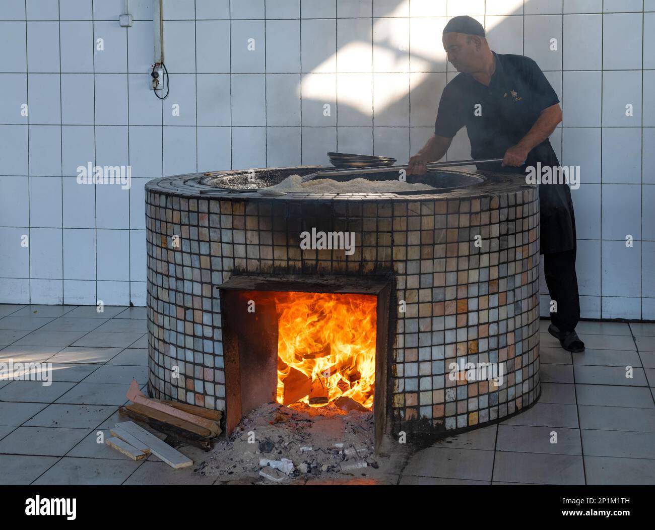 TASHKENT, UZBEKISTAN - SEPTEMBER 04, 2022: Cook stirs rice in a ...