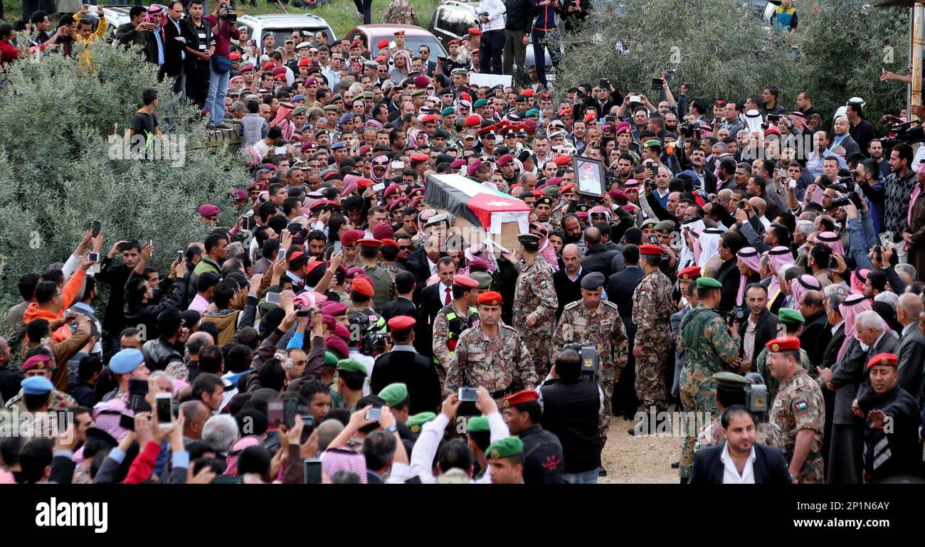 In this picture provided by the Jordanian Royal Palace, Men carry the ...