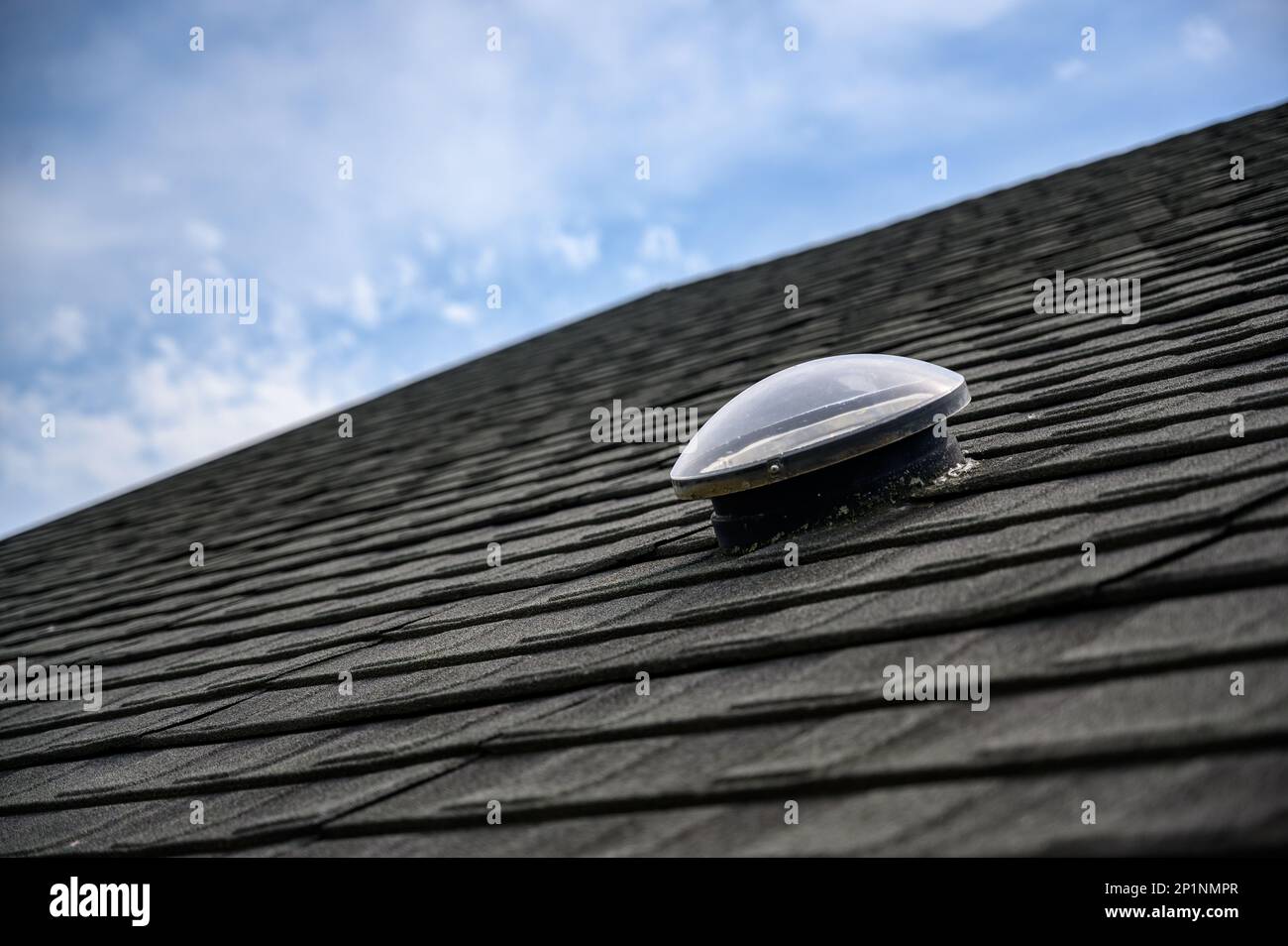 Dome shaped solar tube skylight on asphalt shingle roof Stock Photo - Alamy