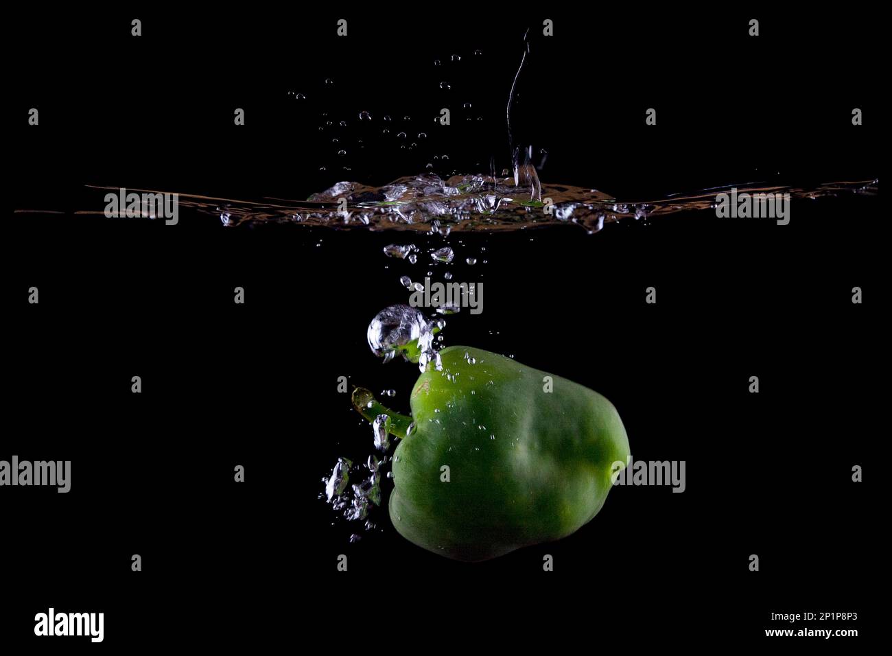 Green bell pepper water splash on black background showing water level ...