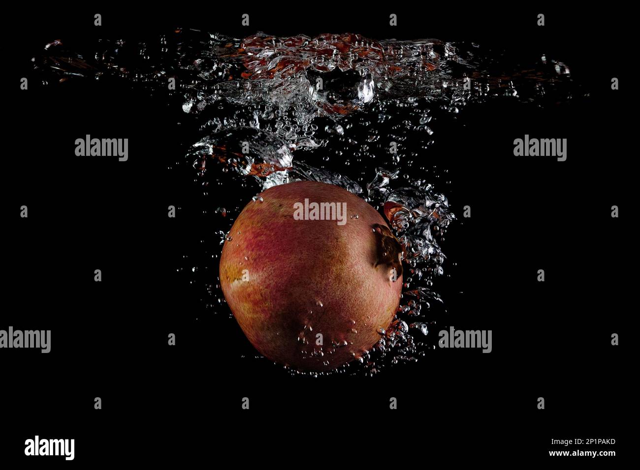 Pomegranate water splash on black background showing water level Stock ...