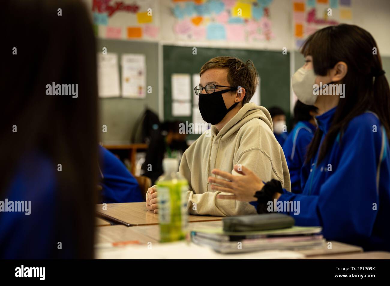 A Kubasaki High School student, center, speaks to Japanese students ...