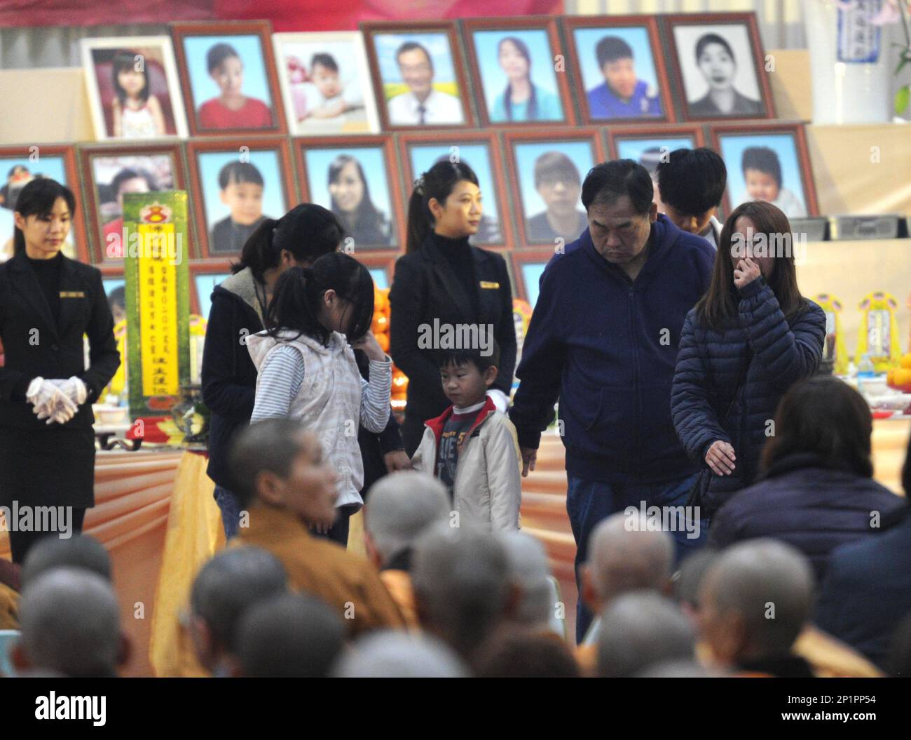 Bereaved family and relatives attend a memorial service on the seventh ...