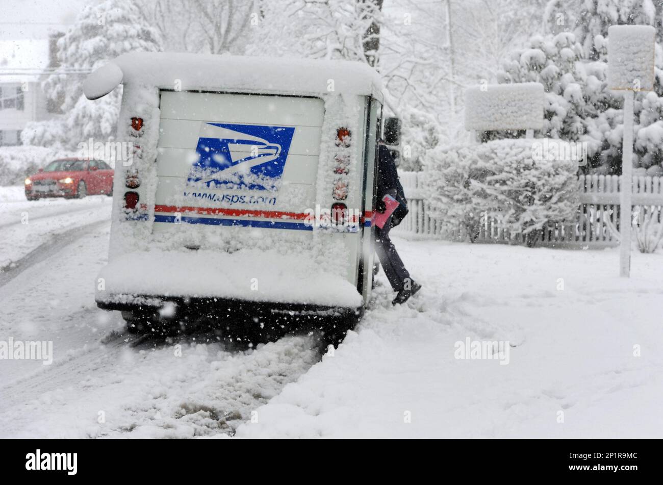 A mailman makes his rounds during an unexpected storm that dumped total ...