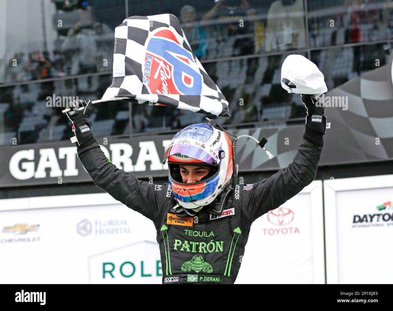 Luis Felipe Derani, of Brazil, waves the checkered flag in Victory Lane ...