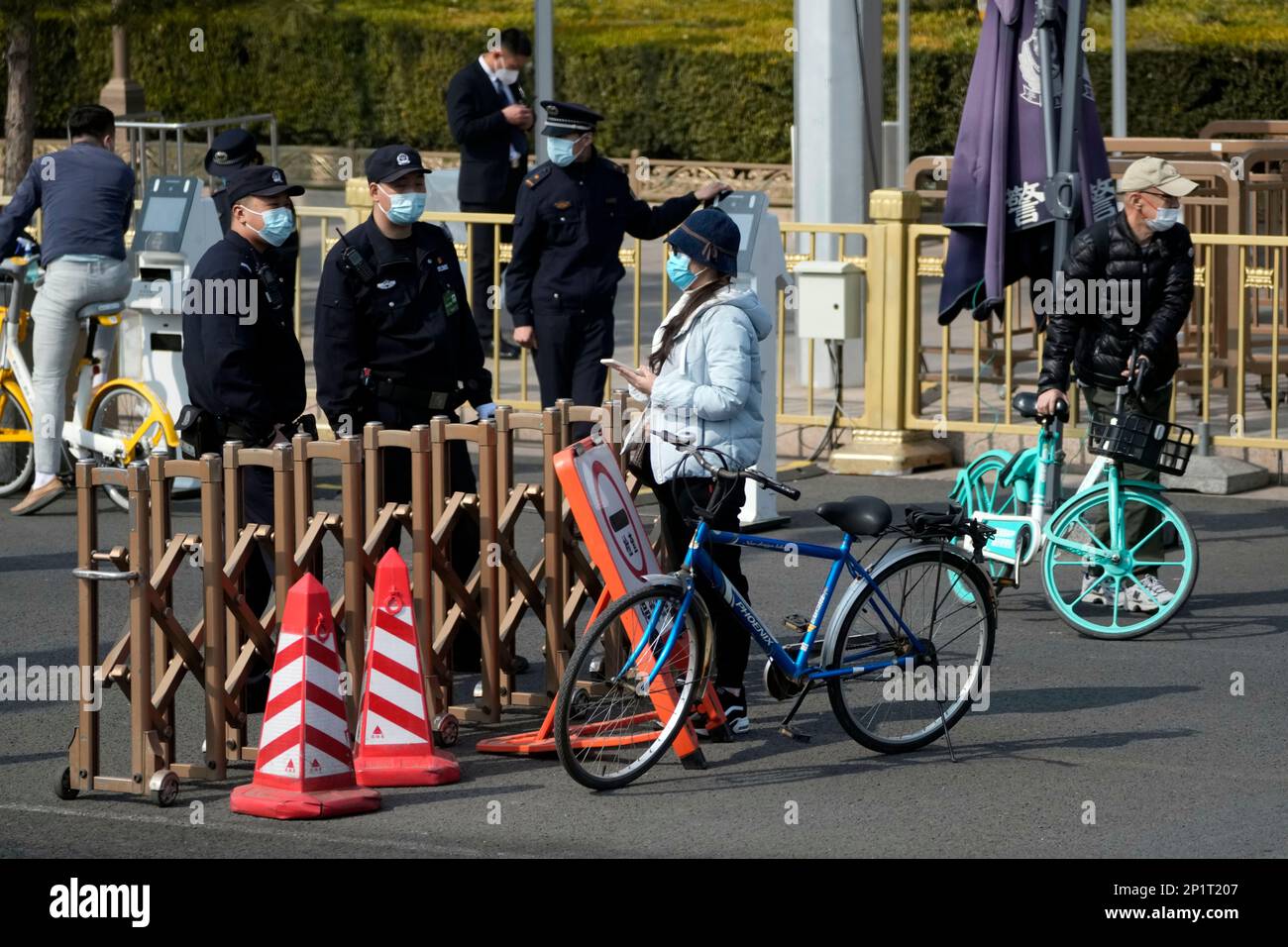 Police officers talk to a woman at a roadblock along a street in ...