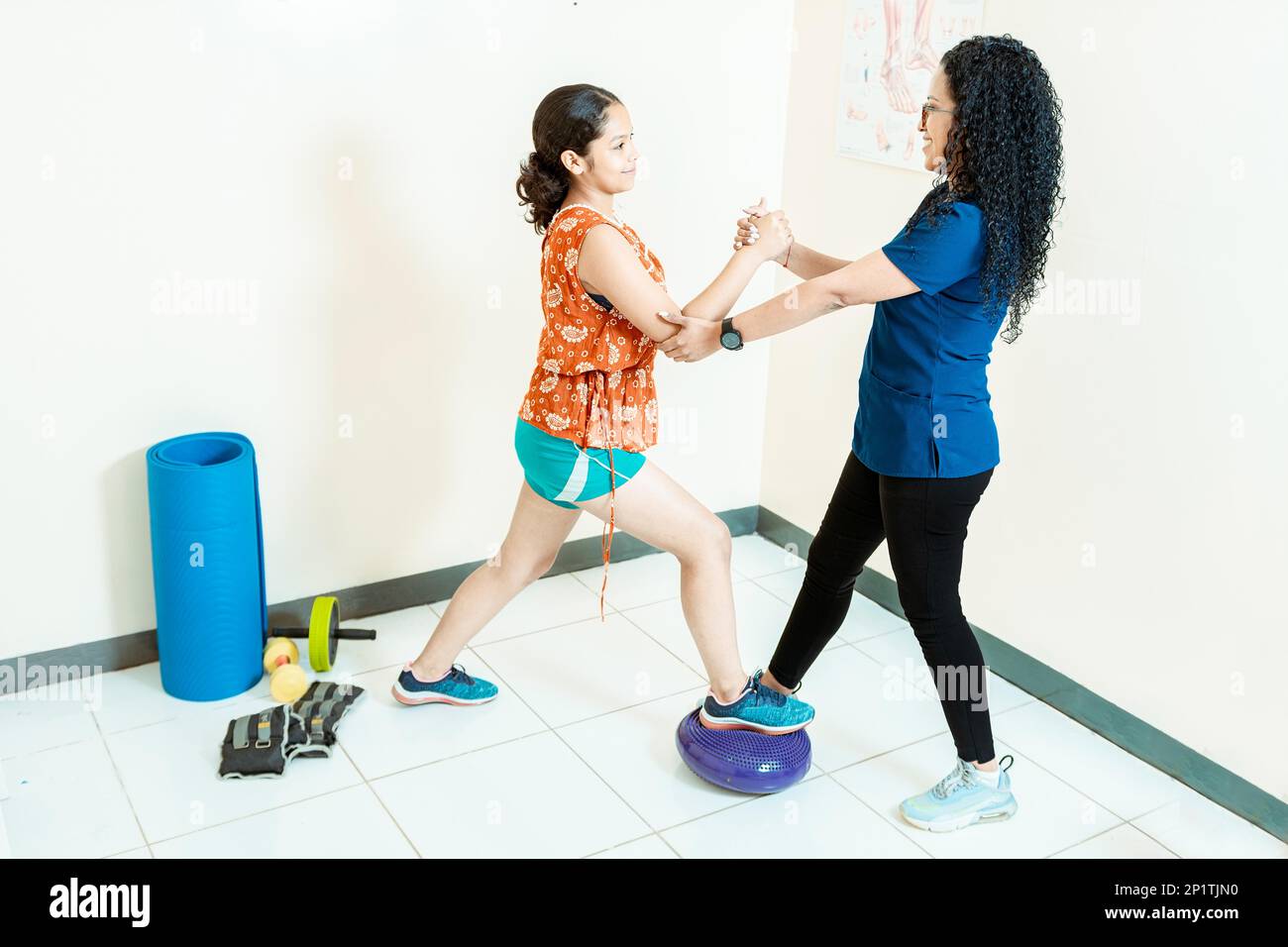 Balance physiotherapy on disc. Physiotherapist woman helping patient on ...