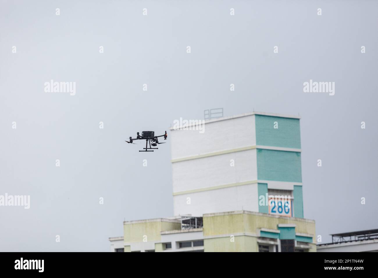 A drone in mid-air is conducting a building inspection to identify any ...